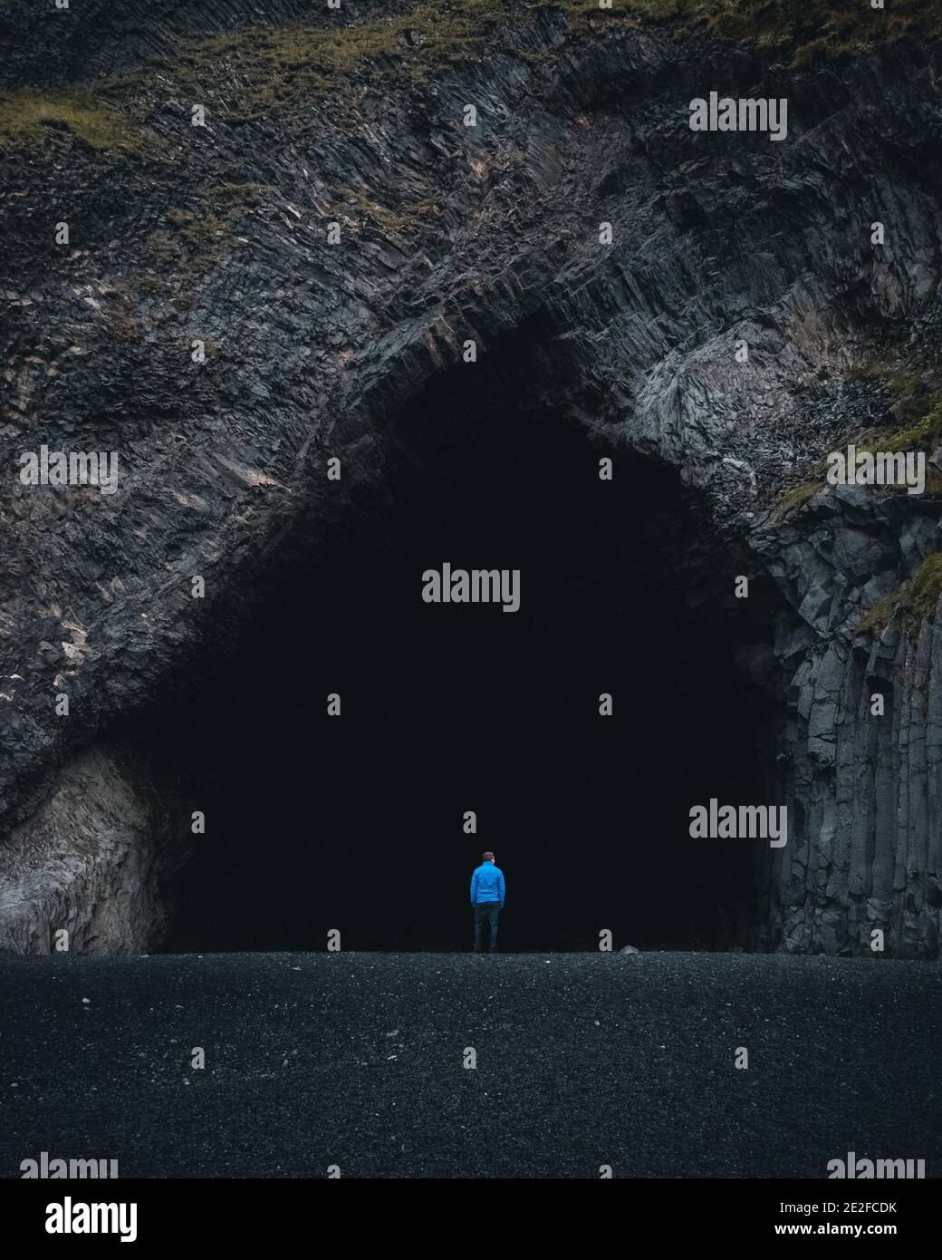 Lonely person standing in front of a huge cave Stock Photo - Alamy