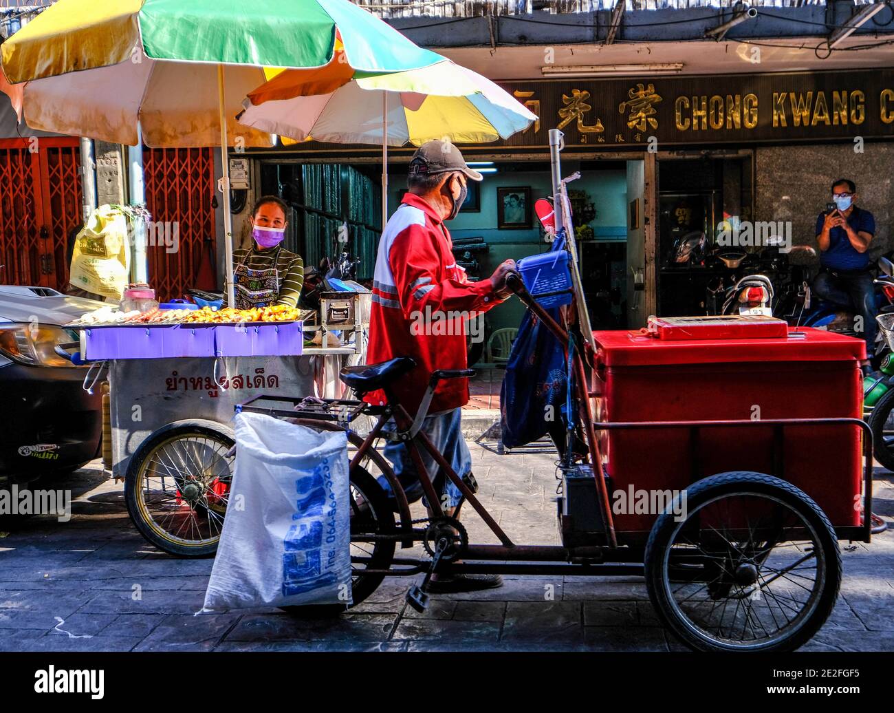 Street vendors stand next to their stalls in Chinatown, Bangkok ...