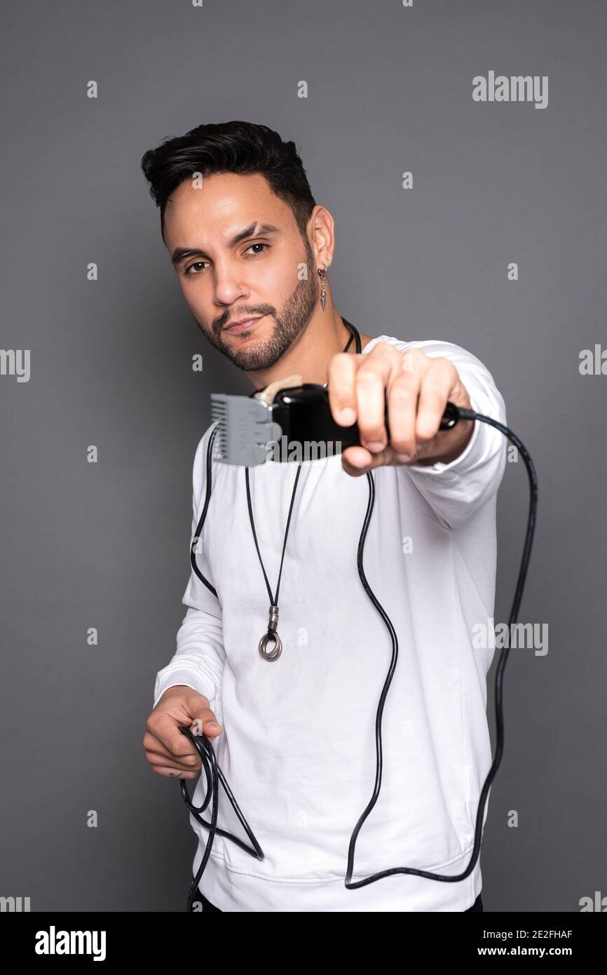 Vertical shot of a barber holding razor on gray background Stock Photo ...