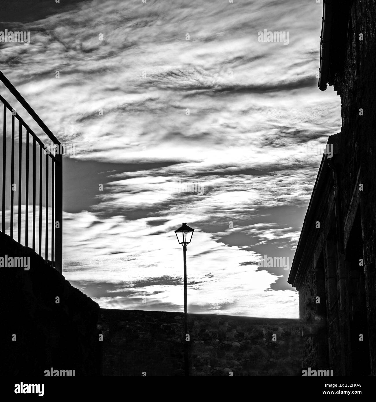 Historic town building exterior walls and an ancient lamp post under a ...