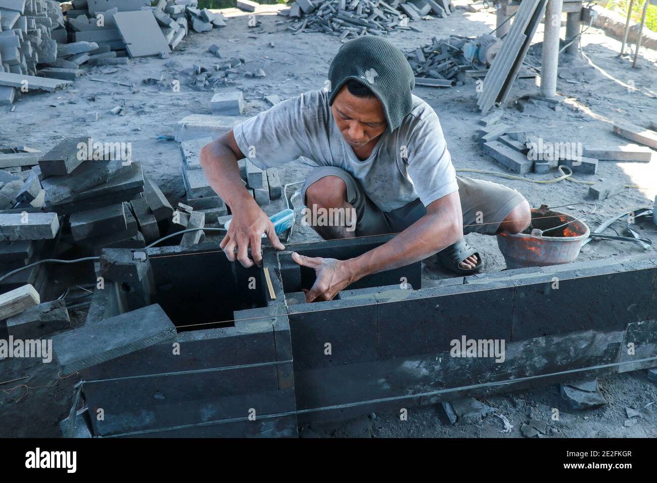 A stonemason makes an altar to a Hindu temple on the island of Bali in ...