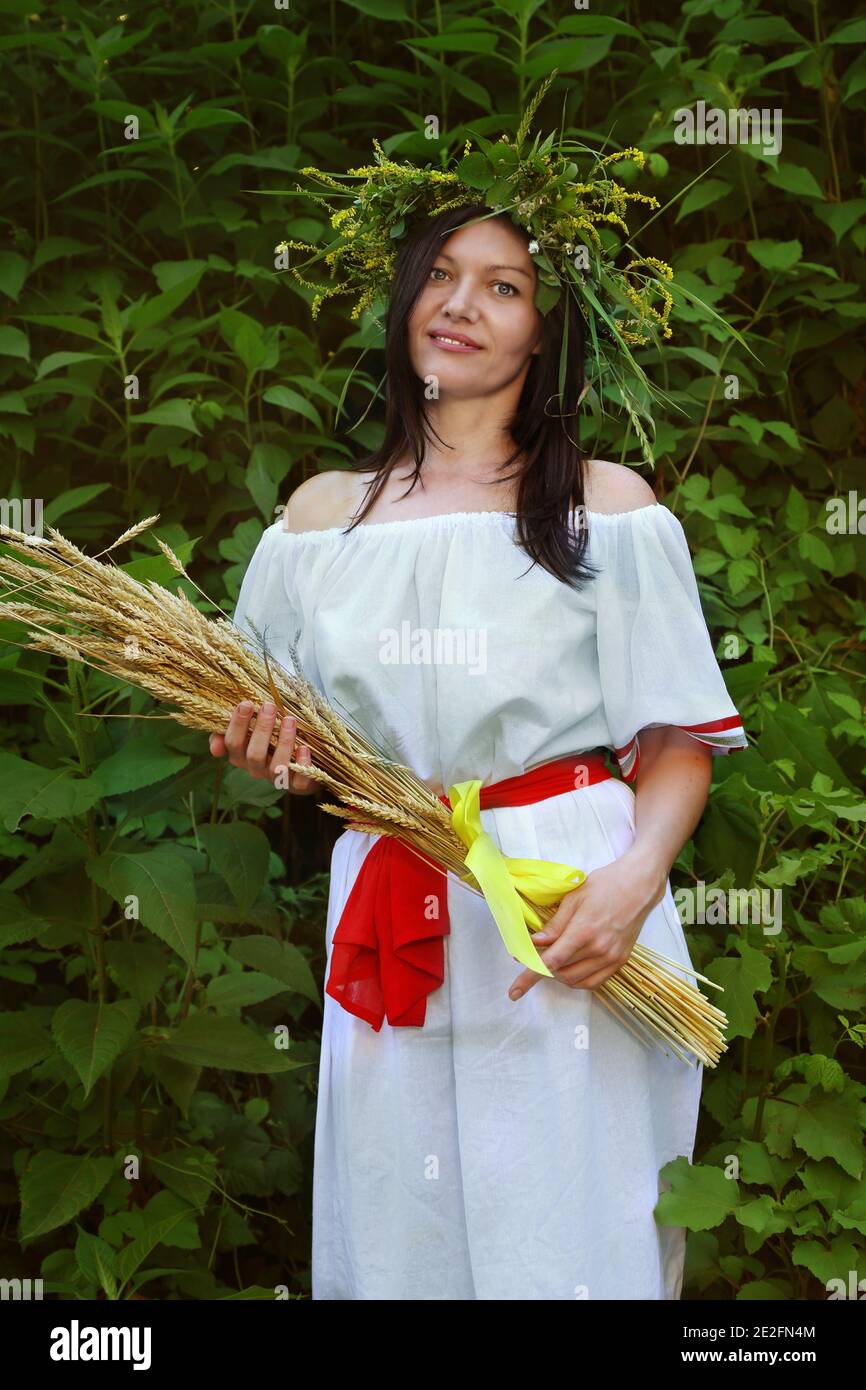 A pagan girl in national dress holds ears of wheat Stock Photo - Alamy