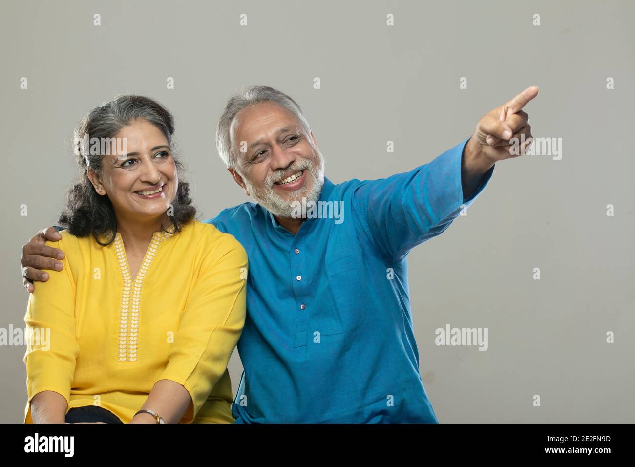 A SENIOR ADULT MAN POINTING AT A FAR AWAY OBJECT AND SHOWING WIFE Stock ...