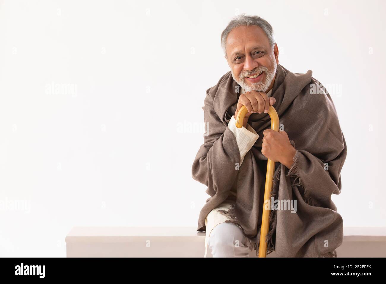 AN OLD MAN WITH WALKING STICK SITTING AND SMILING AT CAMERA Stock Photo ...