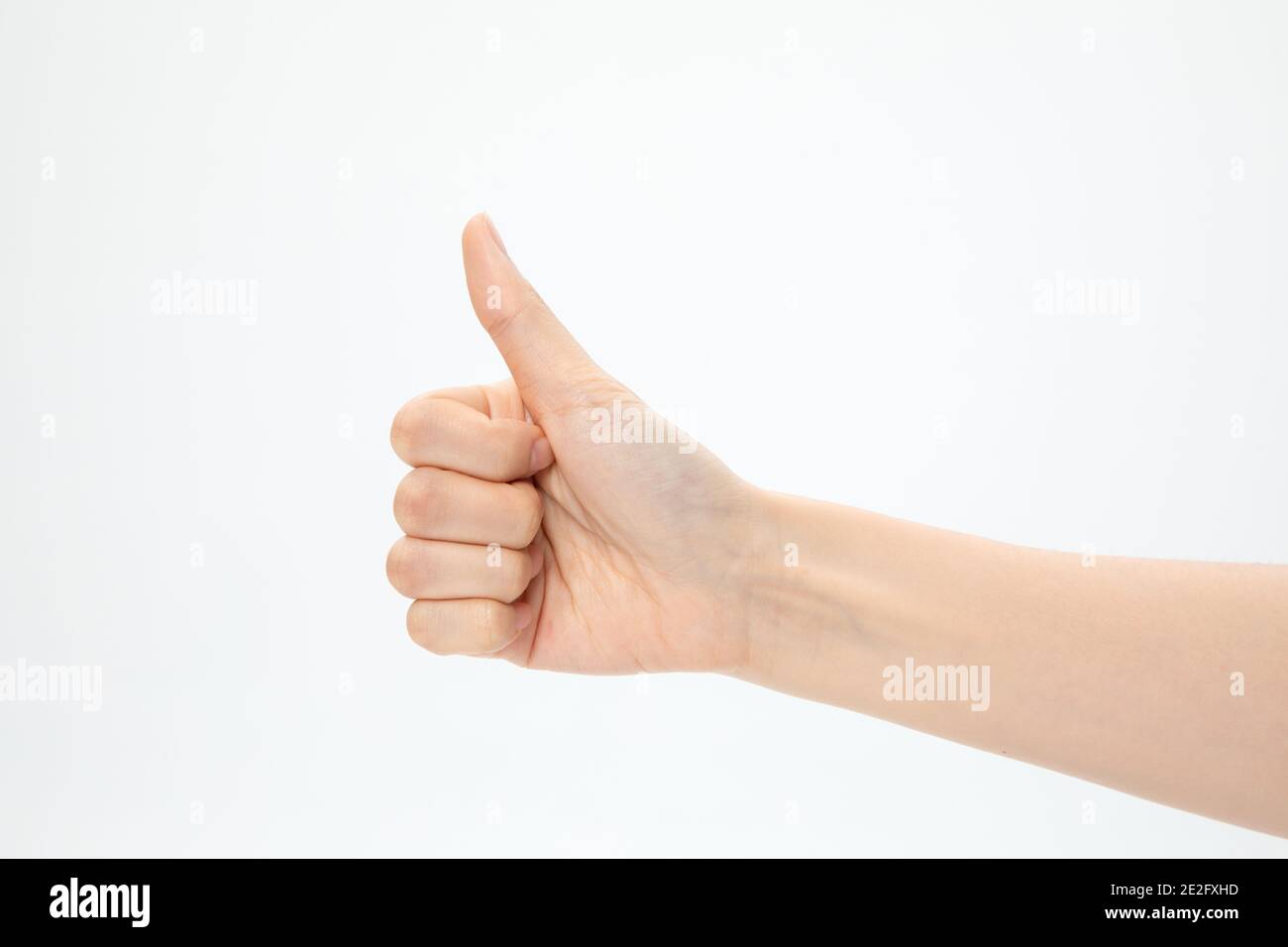 Closeup shot of a hand gesturing a thumbs up isolated on a white ...