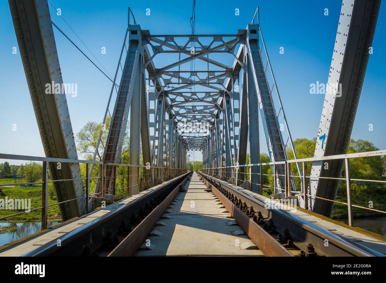Metal railroad bridge in the countryside, clear blue sky background ...