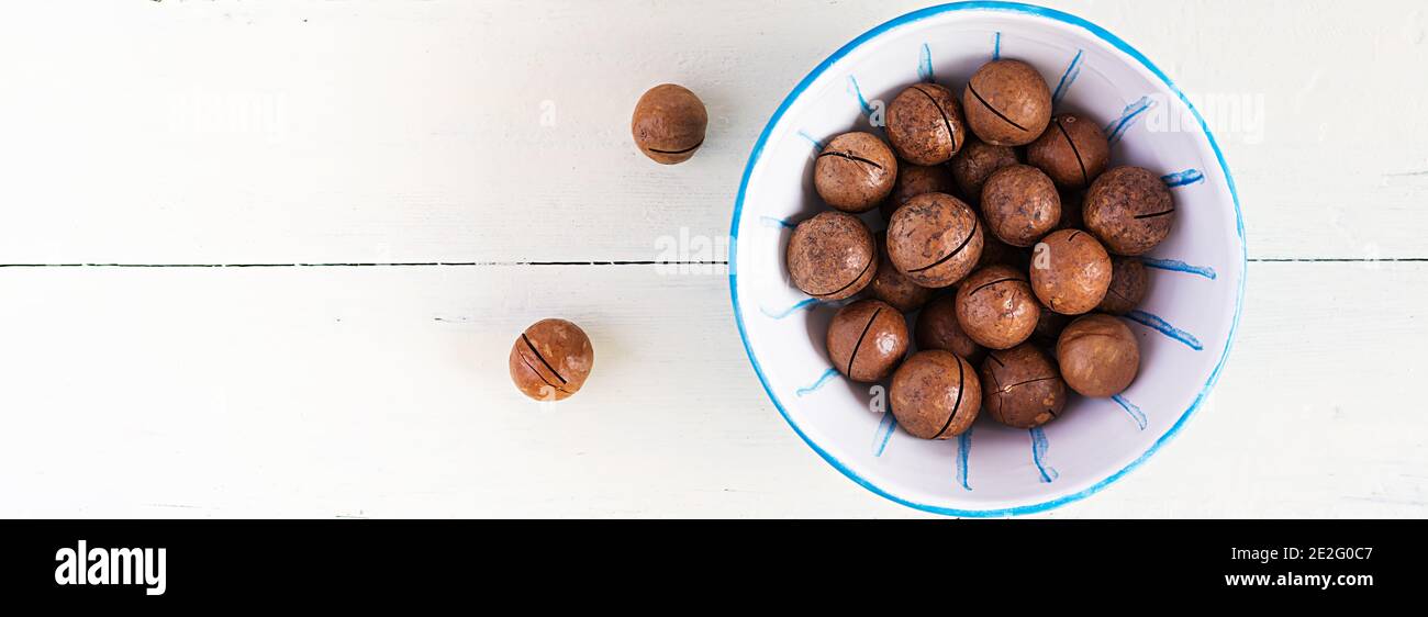 Organic Macadamia nuts (Macadamia integrifolia) in shell on wooden ...