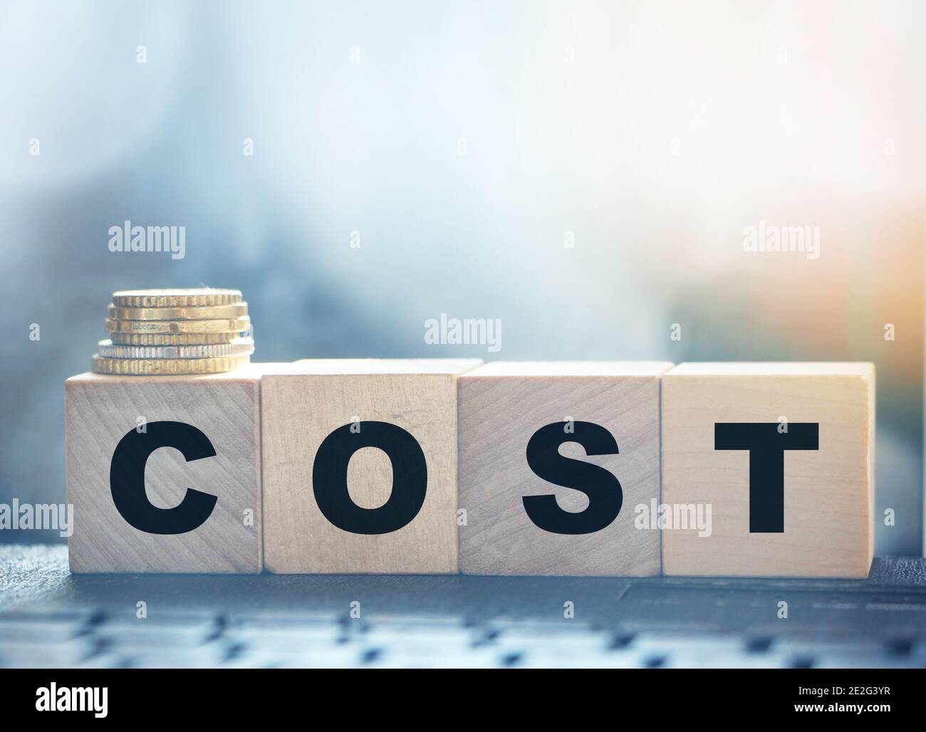 Cost word on cubic wooden blocks with alphabet put on computer keyboard ...