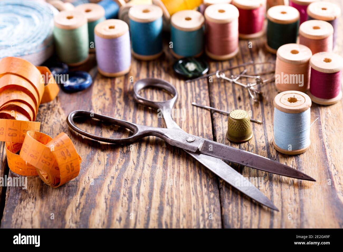 sewing tools : old scissors, bobbins with thread and needles on wooden ...