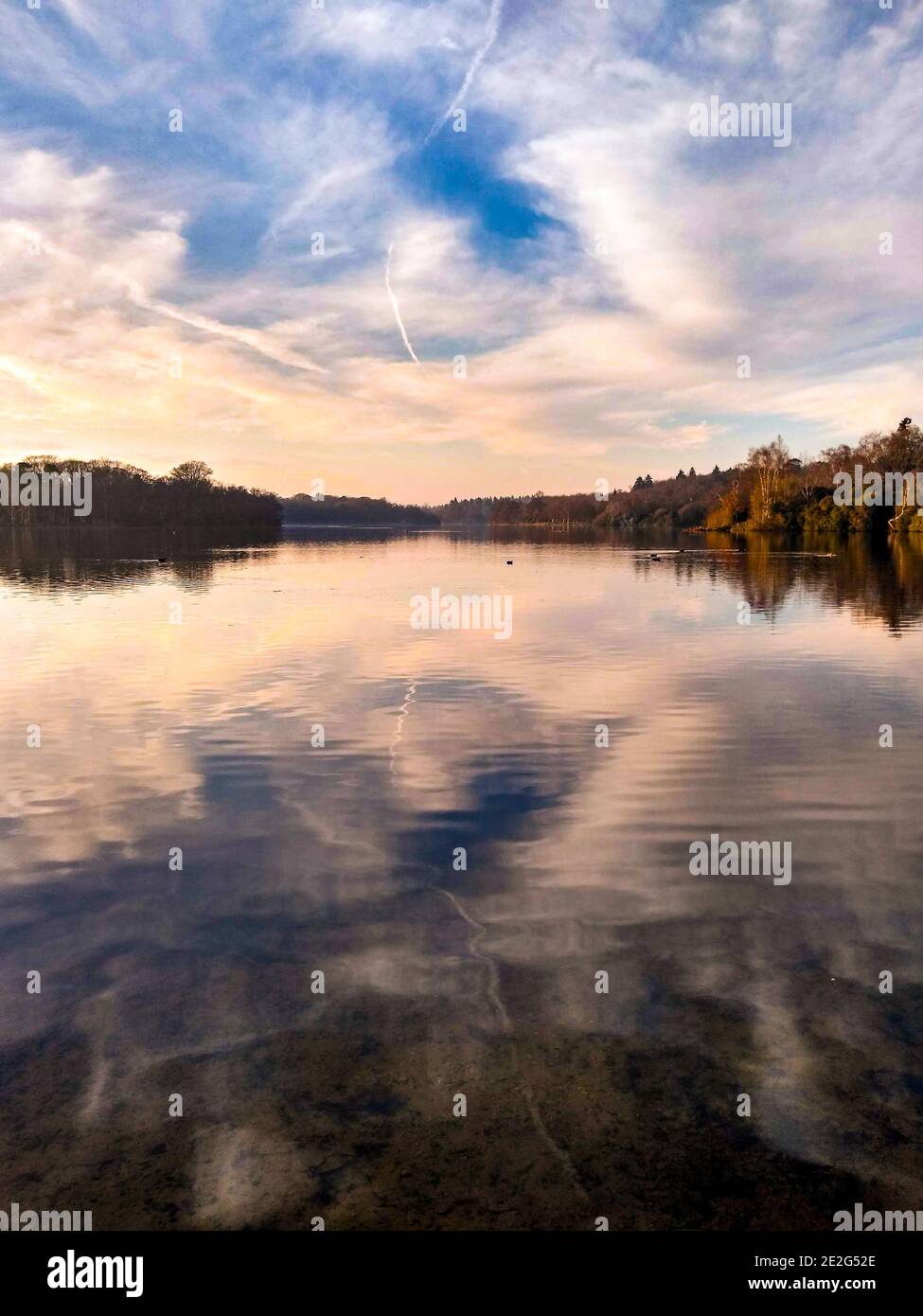 Sunset over Virginia Water lake, Windsor Great Park. Clouds and light ...