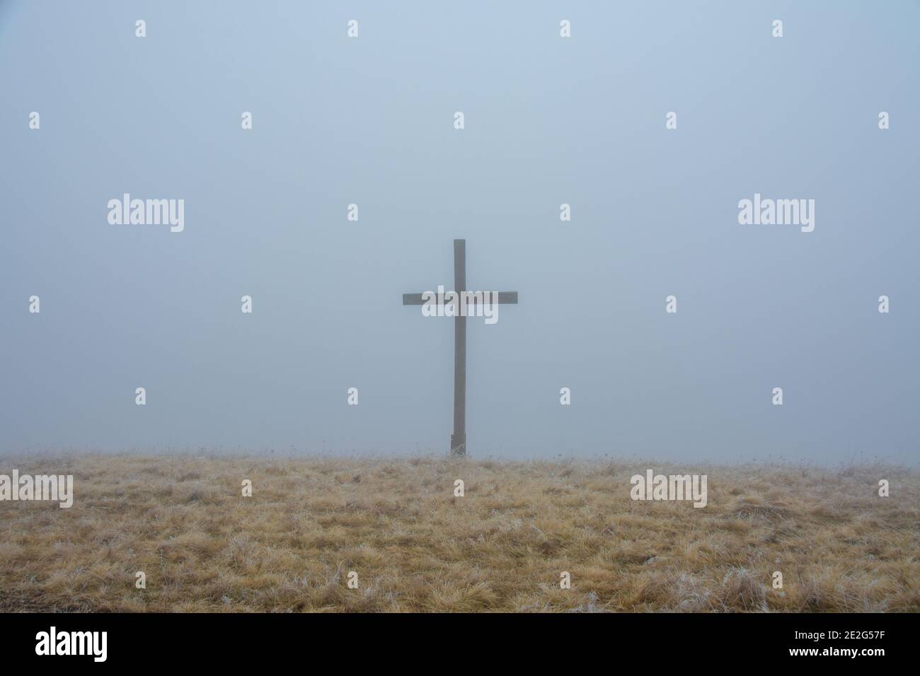 Fantastic shot of a cross in the foggy field Stock Photo - Alamy