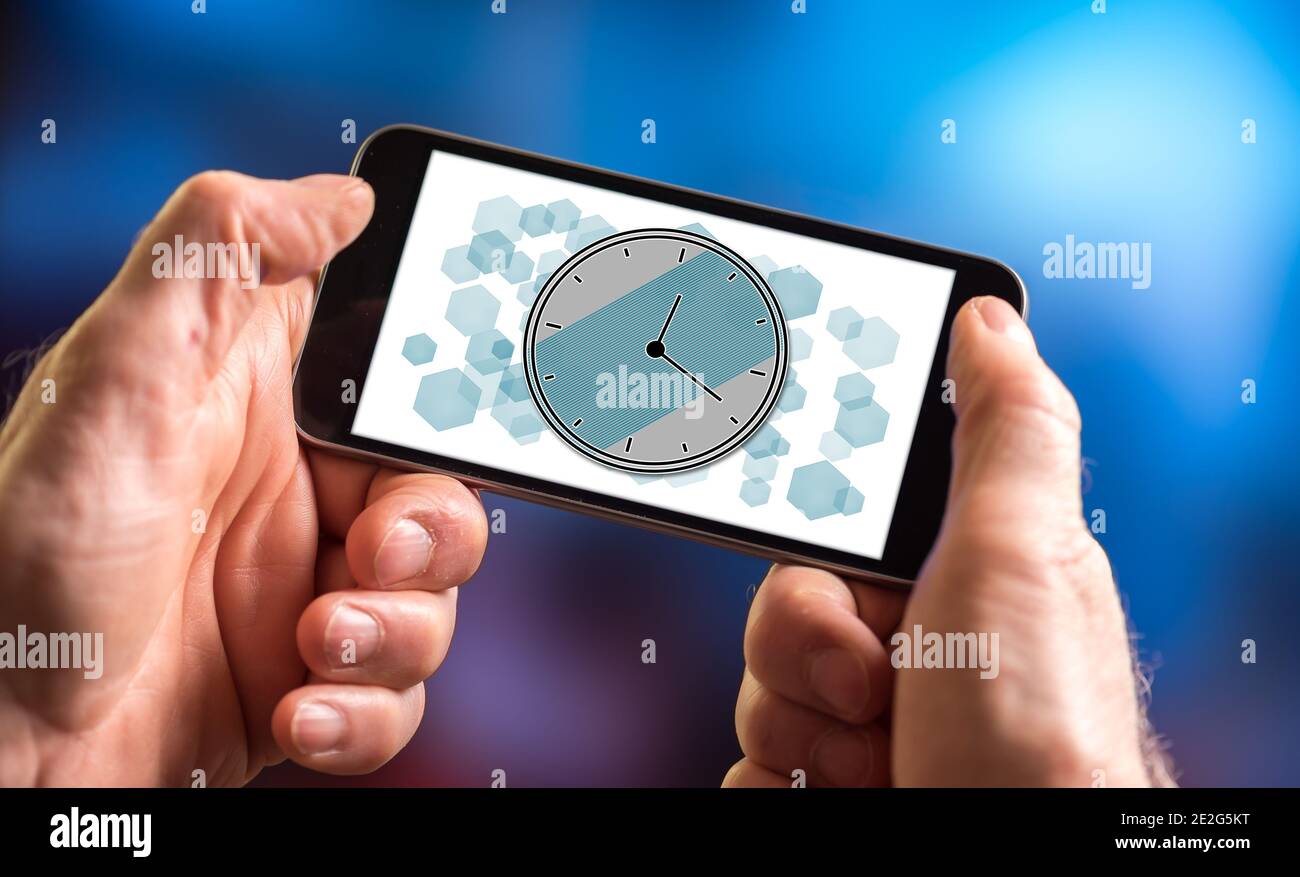 Hand holding a smartphone with time management concept Stock Photo - Alamy