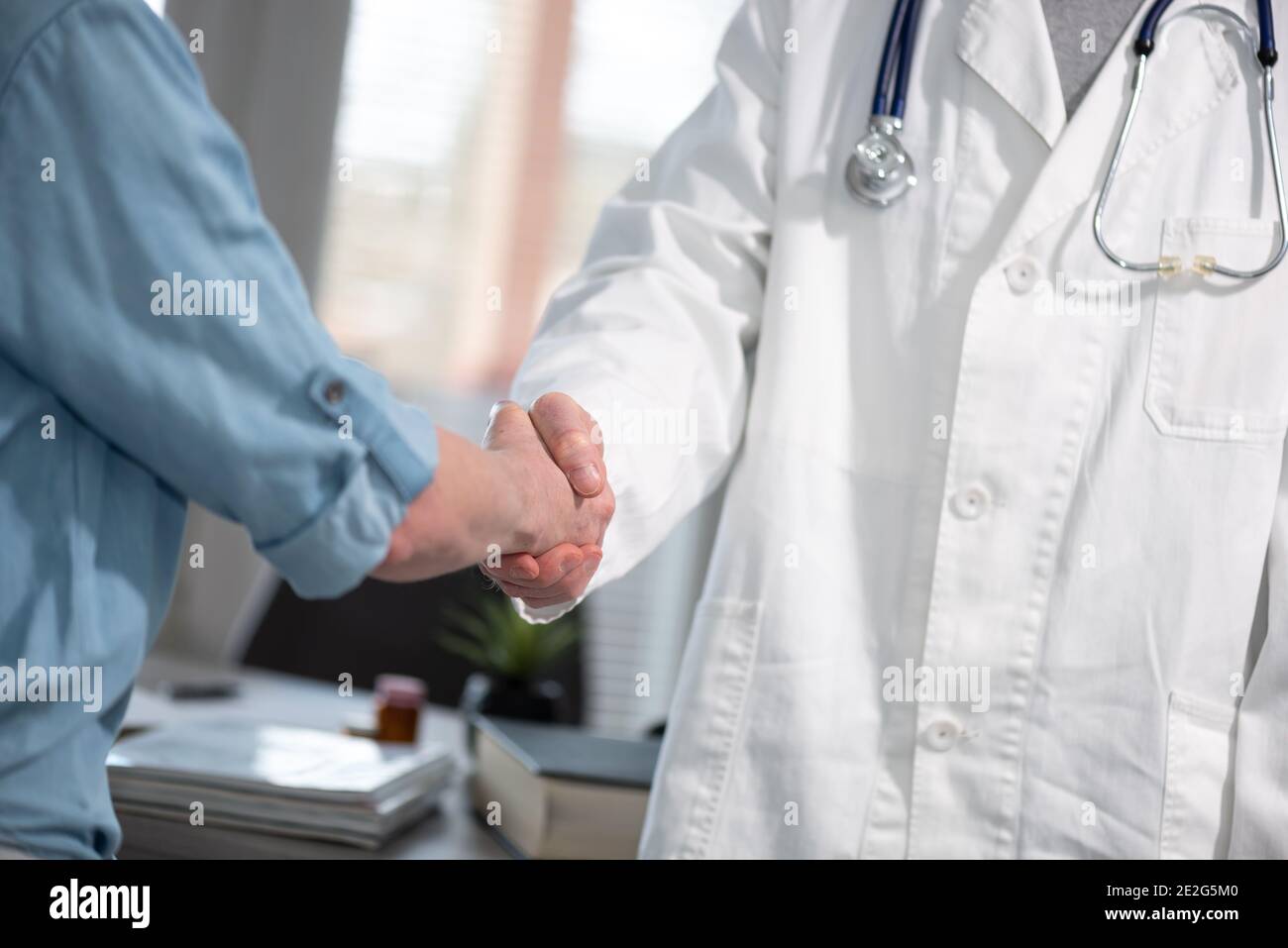 Female doctor shaking hands with her patient Stock Photo - Alamy