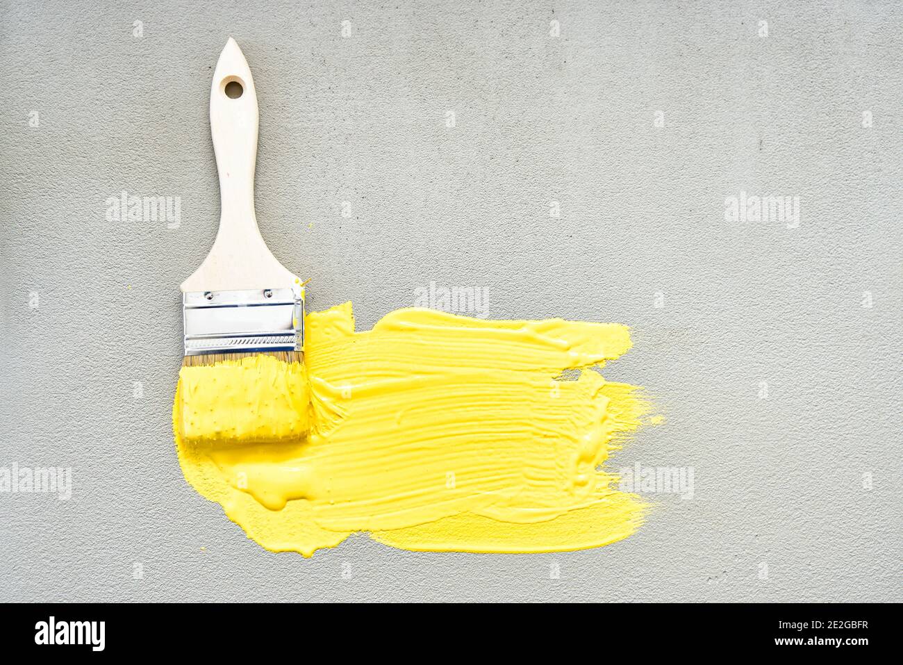 yellow paintbrush in paint on gray background Stock Photo - Alamy