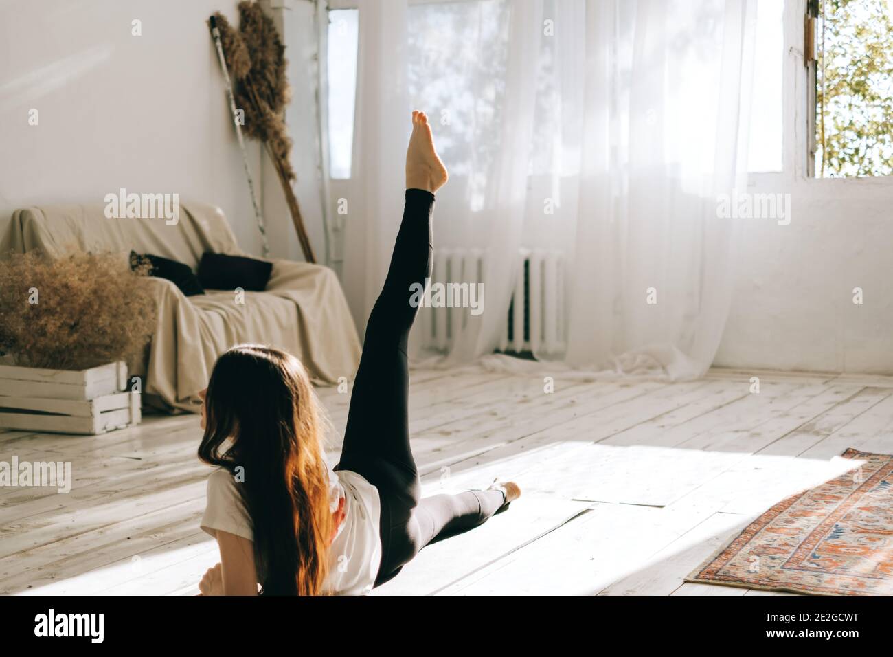 Beautiful brunette fitness woman make stretching exercises indoors at ...