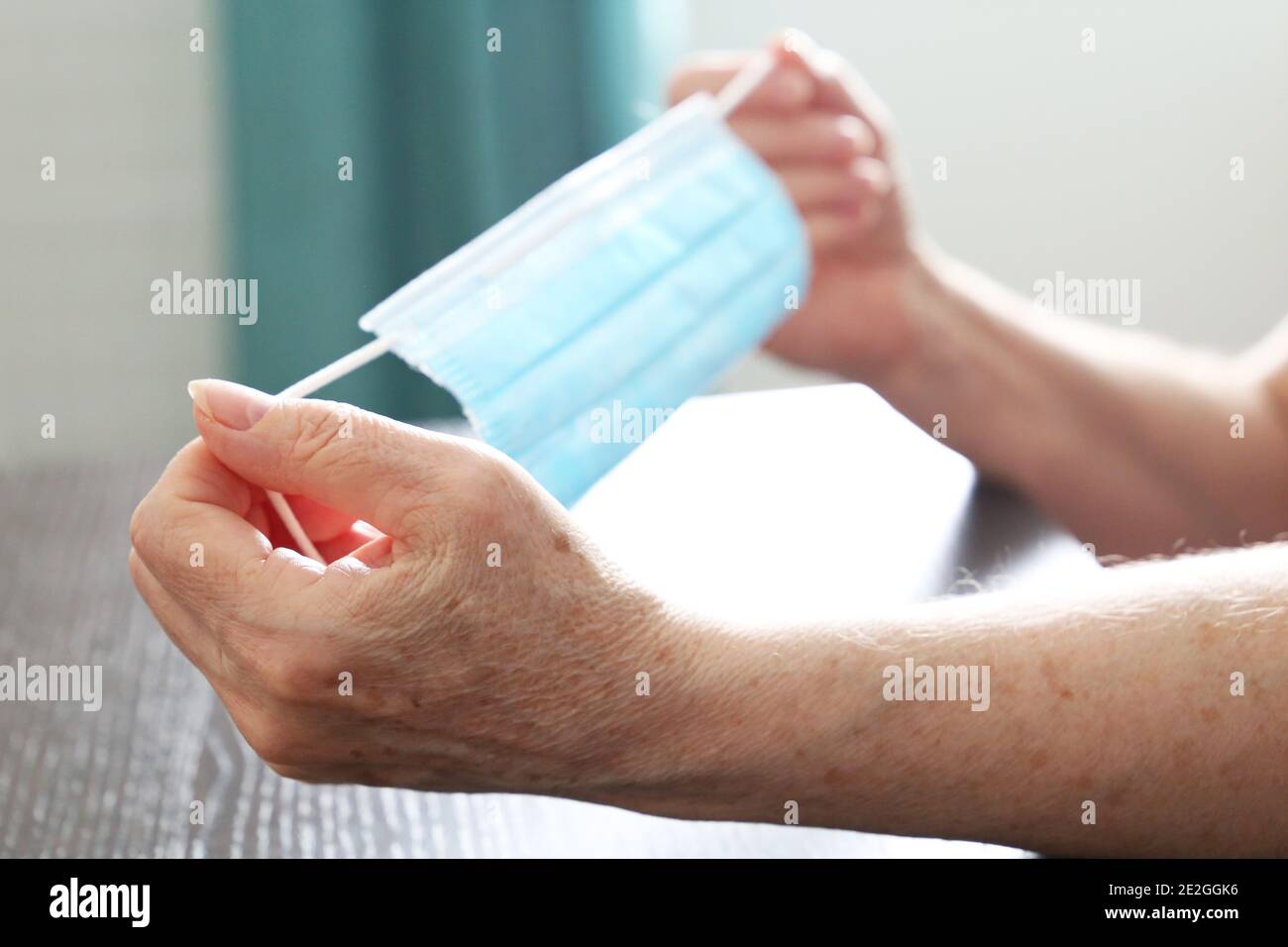 Elderly woman with medical face mask in hands. Coronavirus protection ...