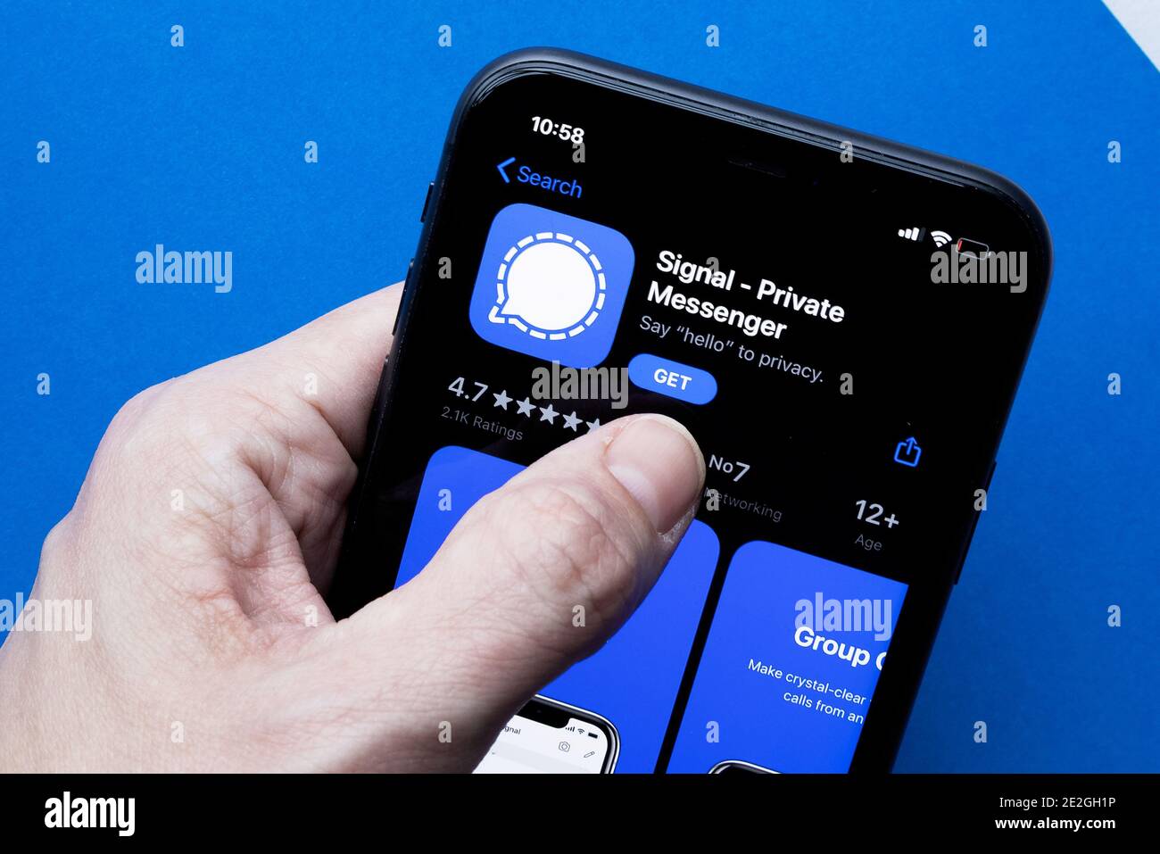 iPhone 11 on blue background with new messenger app Signal logo and ...