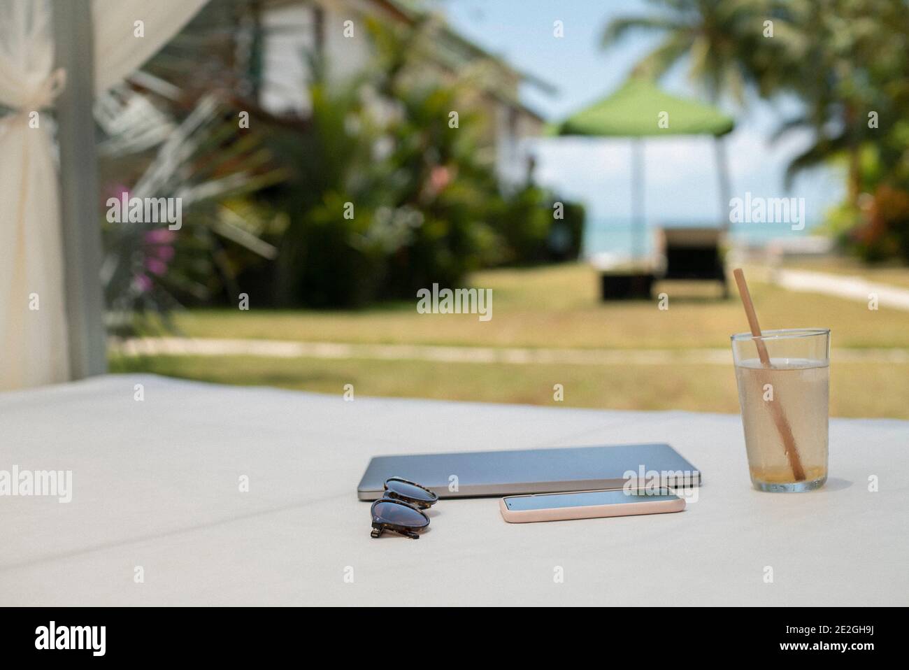 Coconut water, sunglasses, smart phone and notebook on cabana bed Stock ...