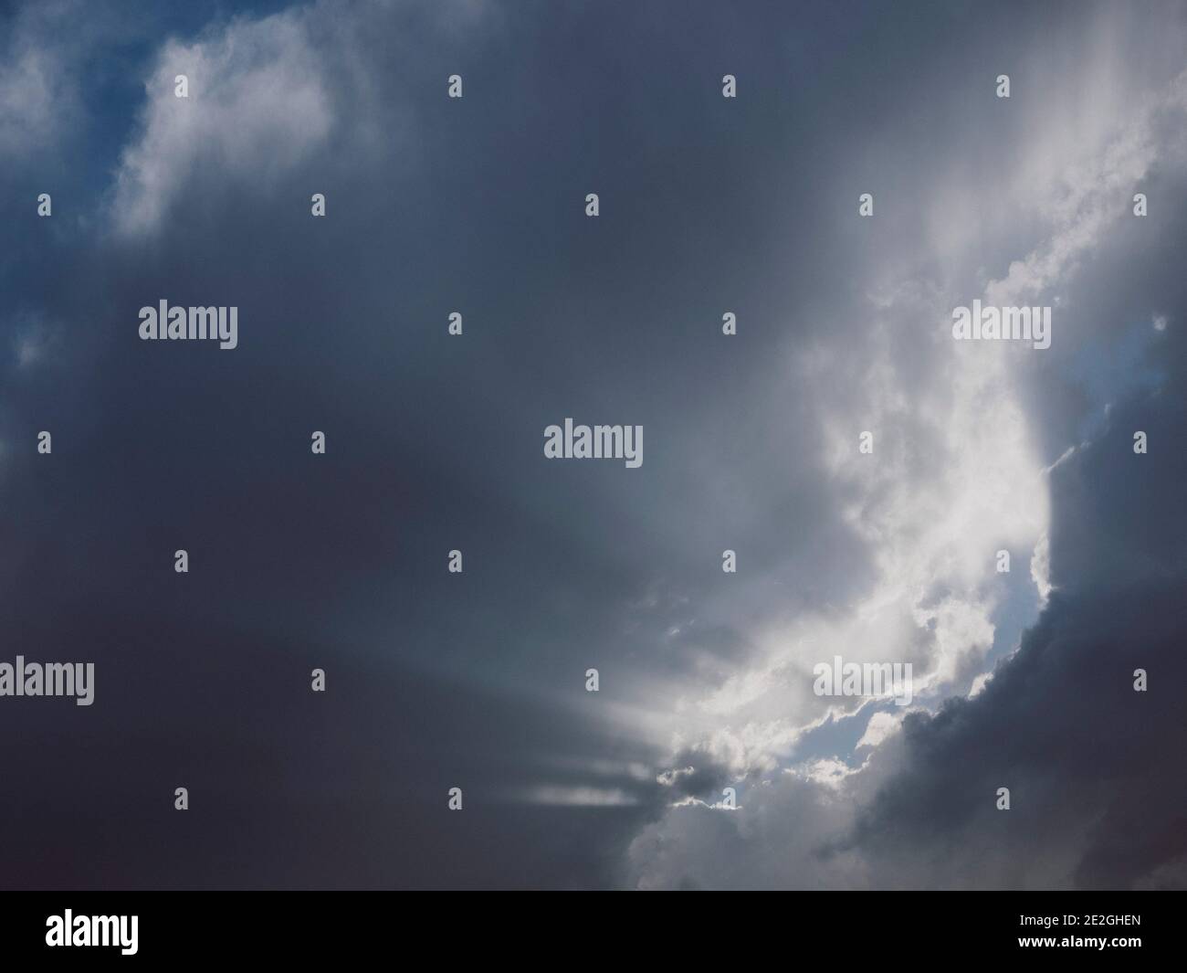 Sunbeams breaking through thick clouds in sky Stock Photo - Alamy