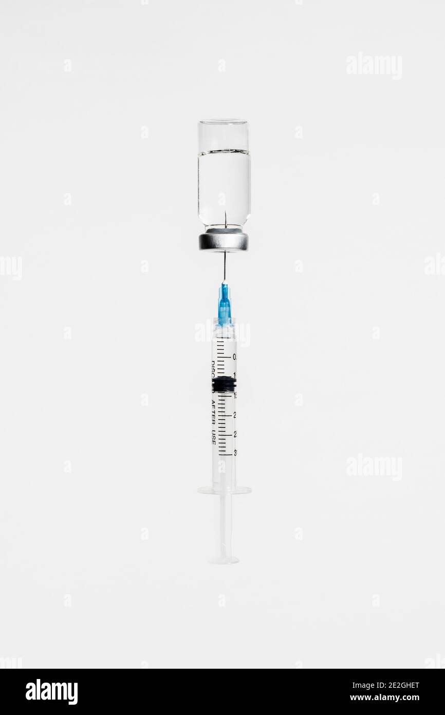 Syringe in COVID-19 vaccine vial on white background Stock Photo - Alamy