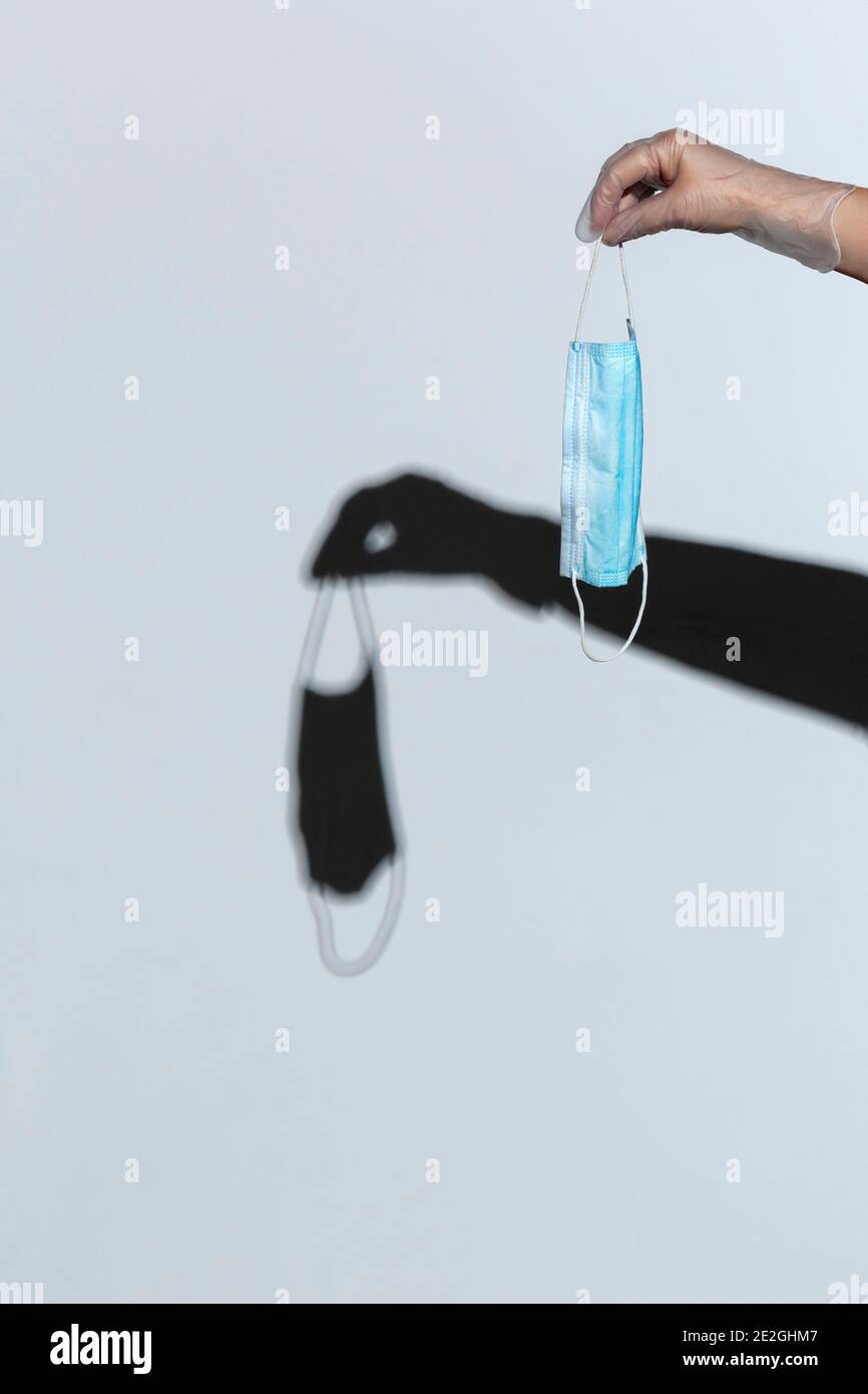 Gloved hand holding disposable protective face mask Stock Photo - Alamy