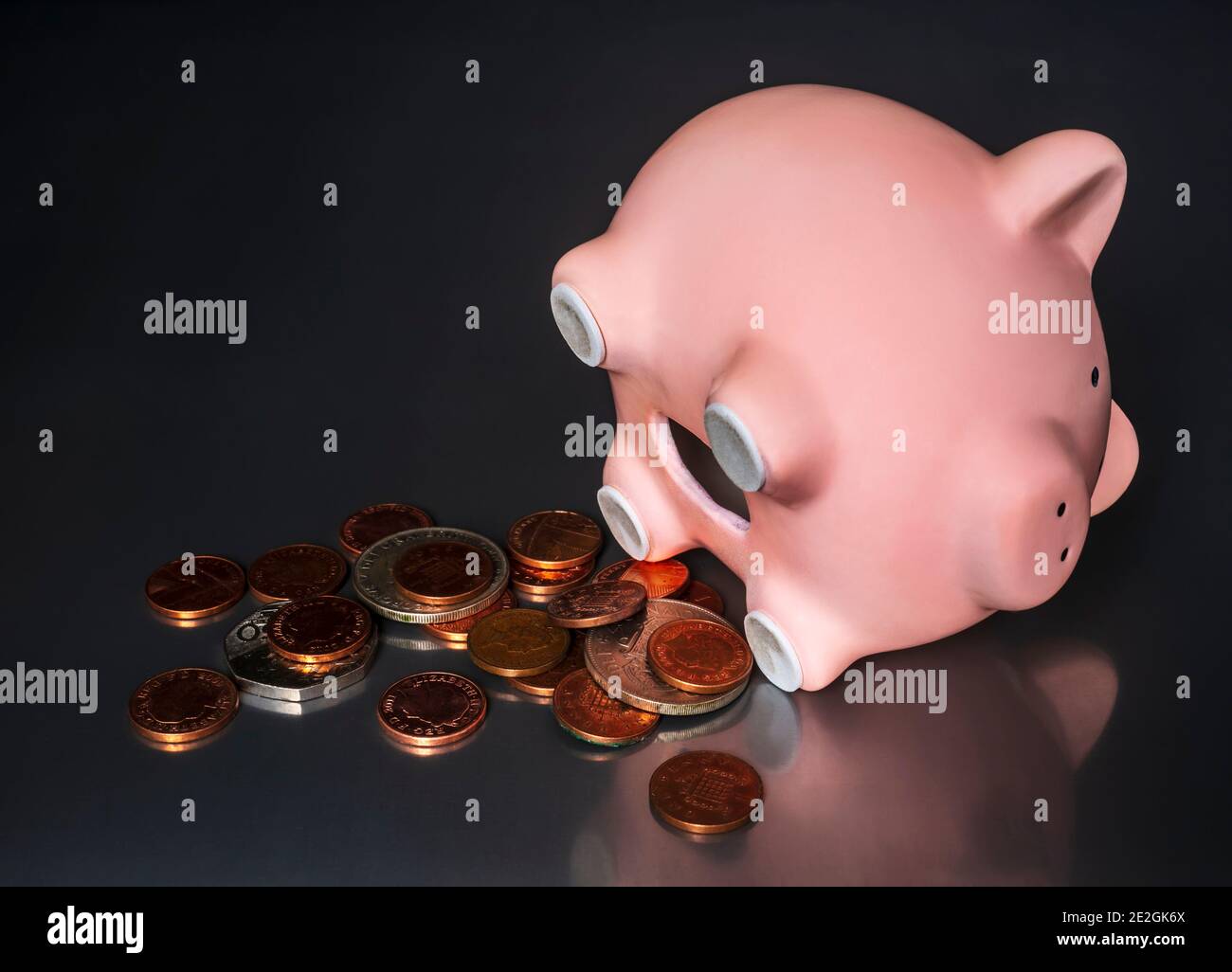 Money spilling from a Piggy Bank Stock Photo - Alamy