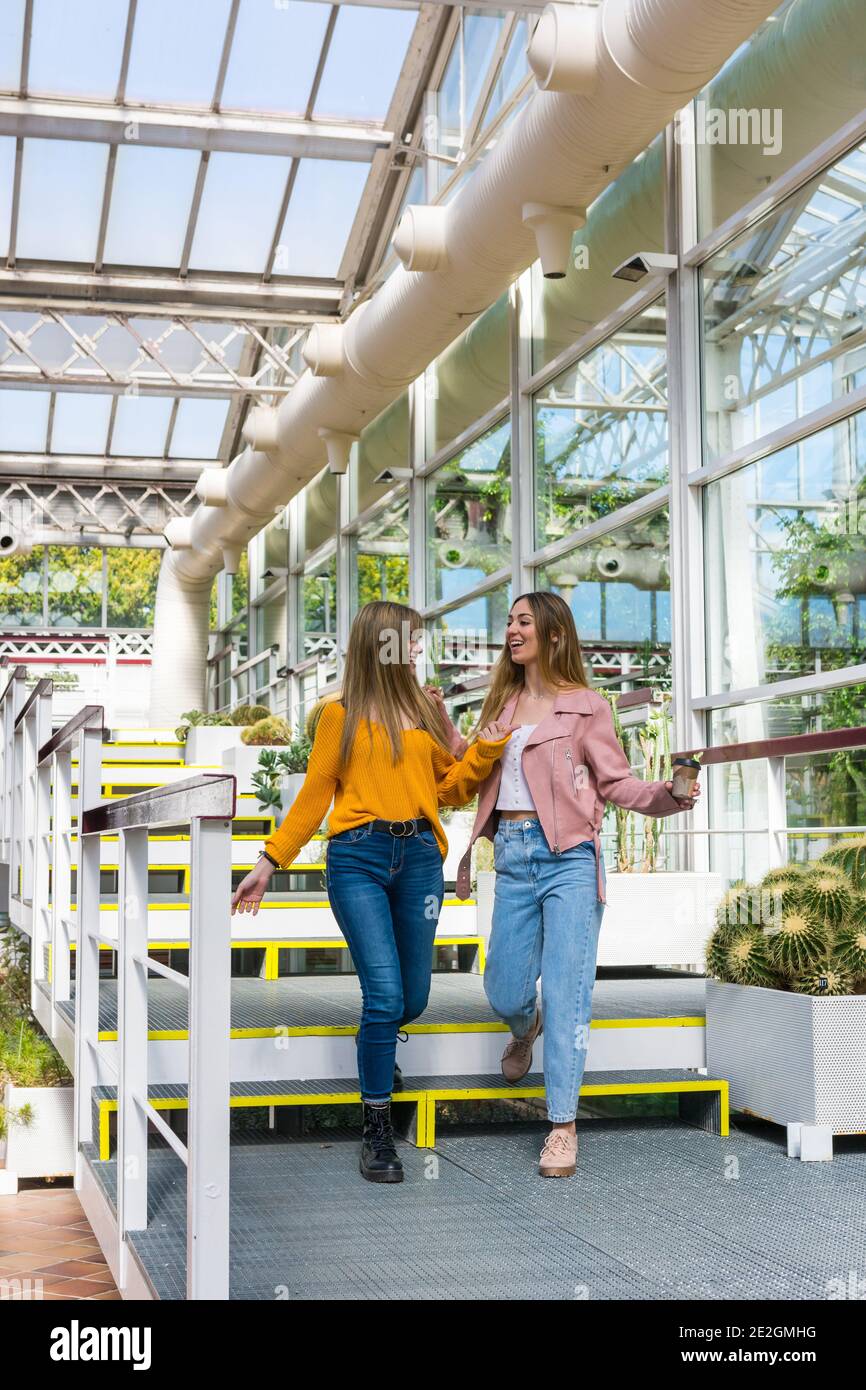 Two friends walk through a park and tell each other their secrets while ...