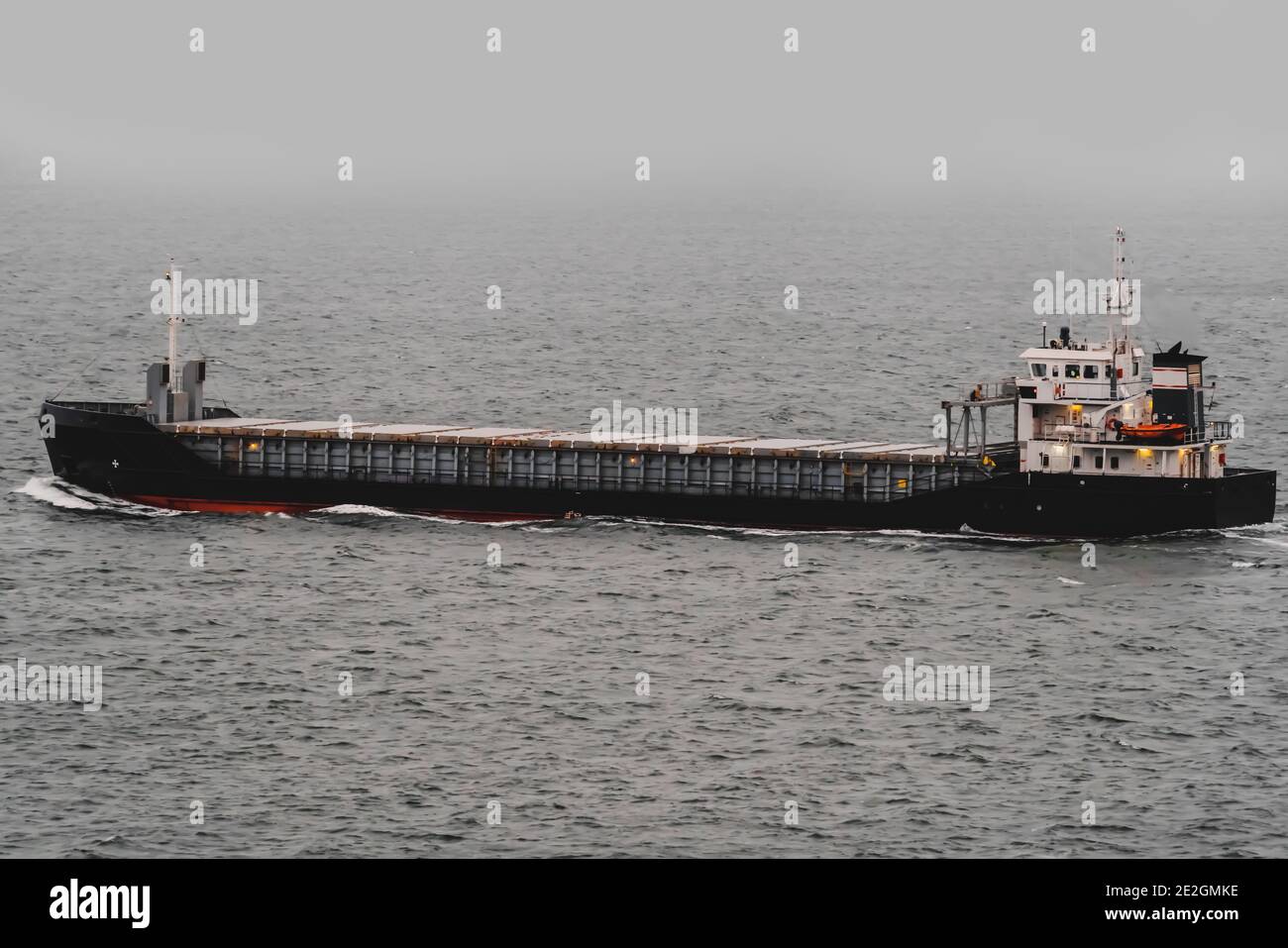 Small cargo ship sailing through dense fog at sea Stock Photo - Alamy