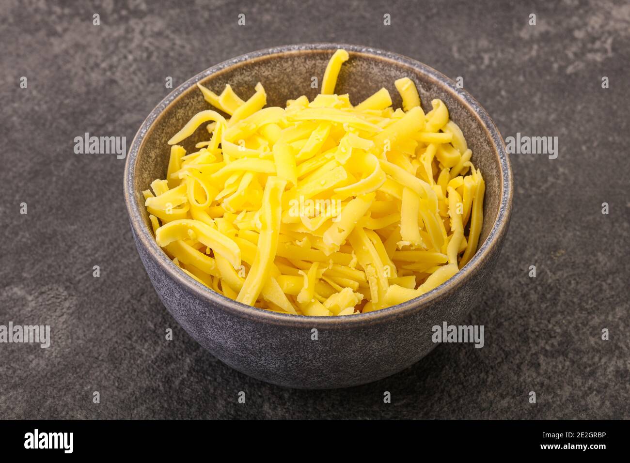 Shredded yellow cheese in the bowl for cooking Stock Photo - Alamy
