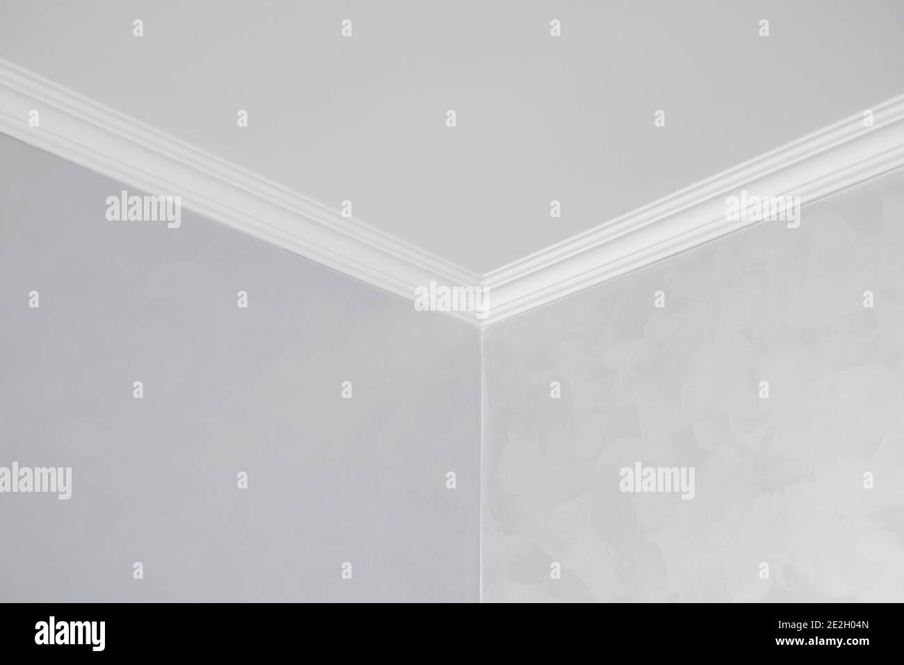 White ceiling with a white plinth in a room with gray painted walls ...