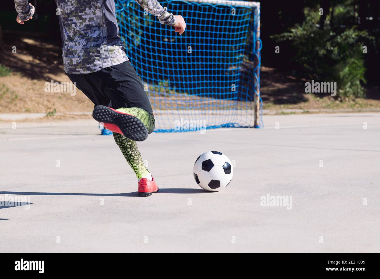 Person Kicking A Soccer Ball Into The Goal