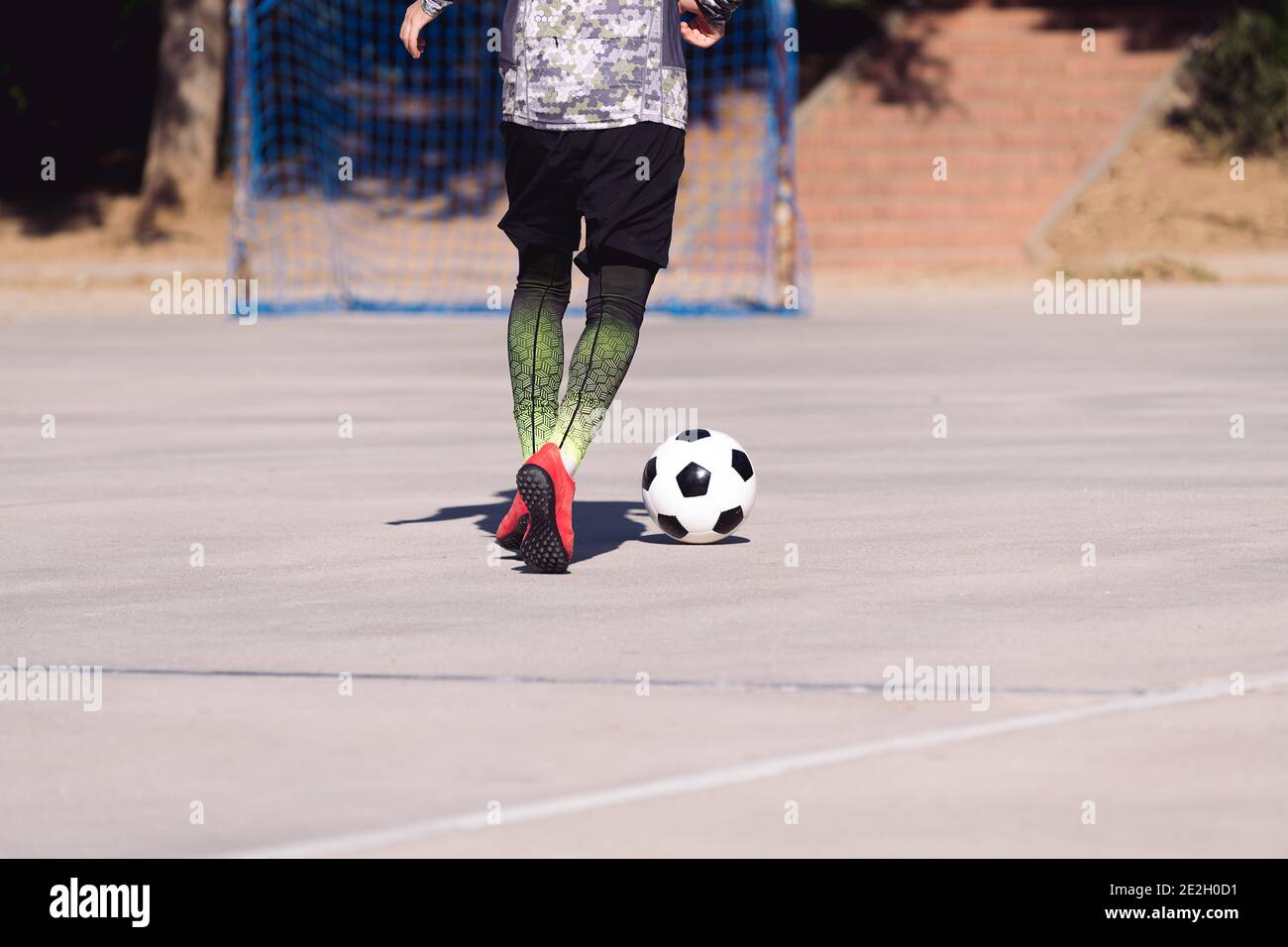 rear view of the legs of a sportsman playing the soccer ball in a ...