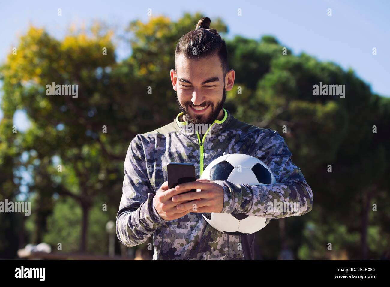 happy sportsman with a soccer ball smiles writing a message on his ...