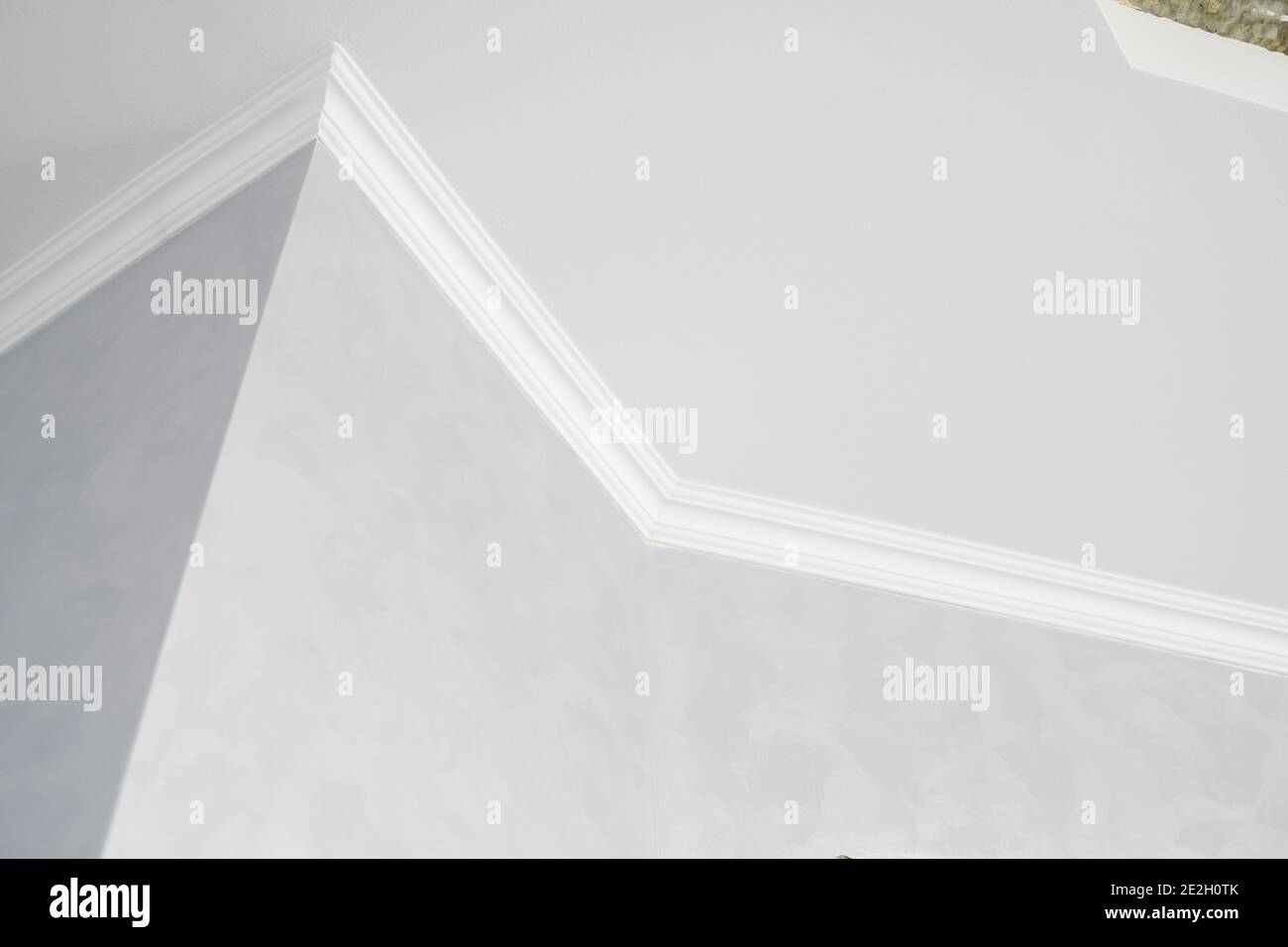 White ceiling with a white plinth in a room with gray painted walls ...