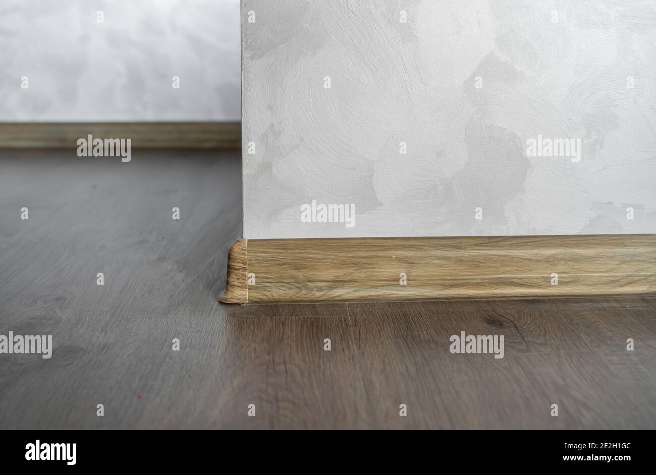 Laminate with plastic baseboard with a wooden texture. Newly installed ...