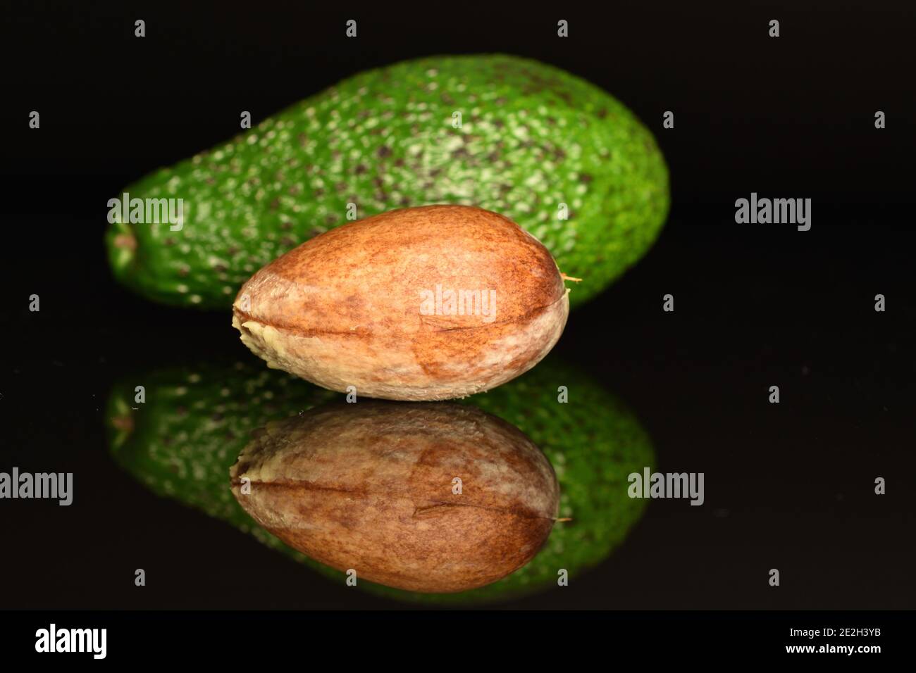 One whole green delicious dietary avocado is located behind one whole ...