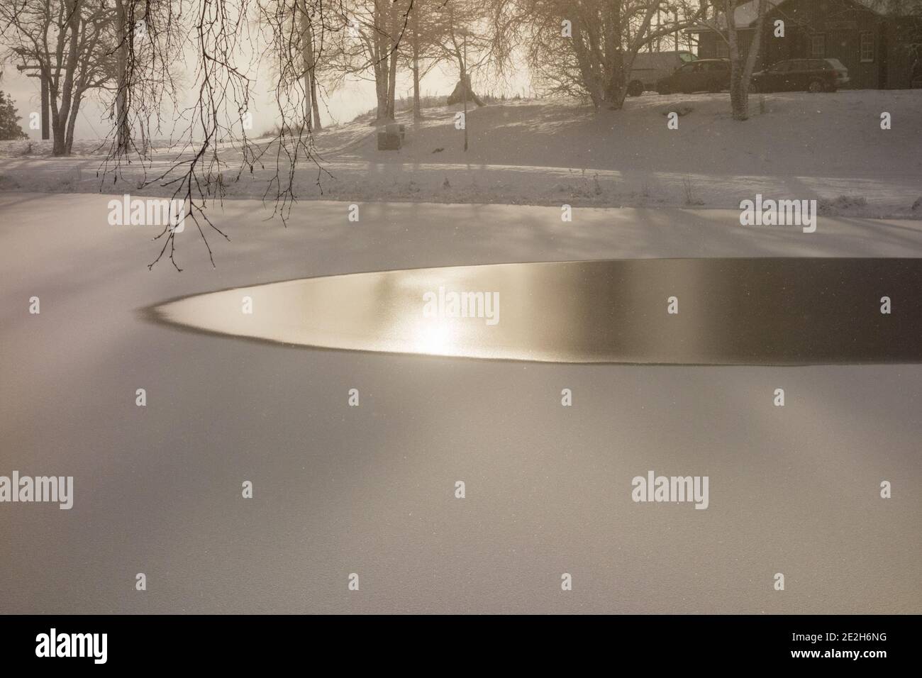 Melted water pole on the lake in back light Stock Photo - Alamy