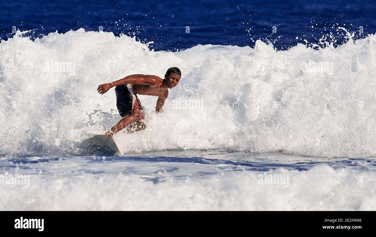 Surfer school. A young guy learning to stand on a surfboard. Surfer on ...