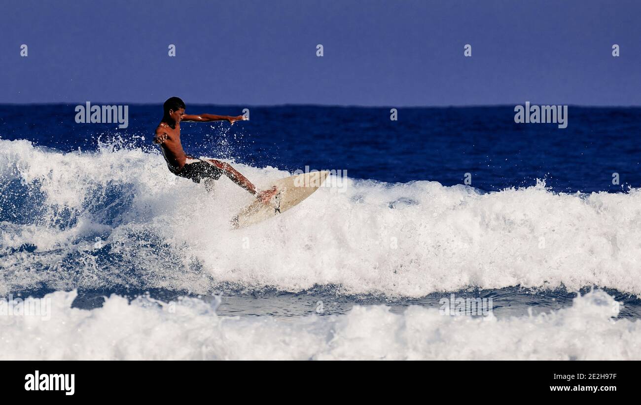 Surfer school. A young guy learning to stand on a surfboard. Surfer on ...