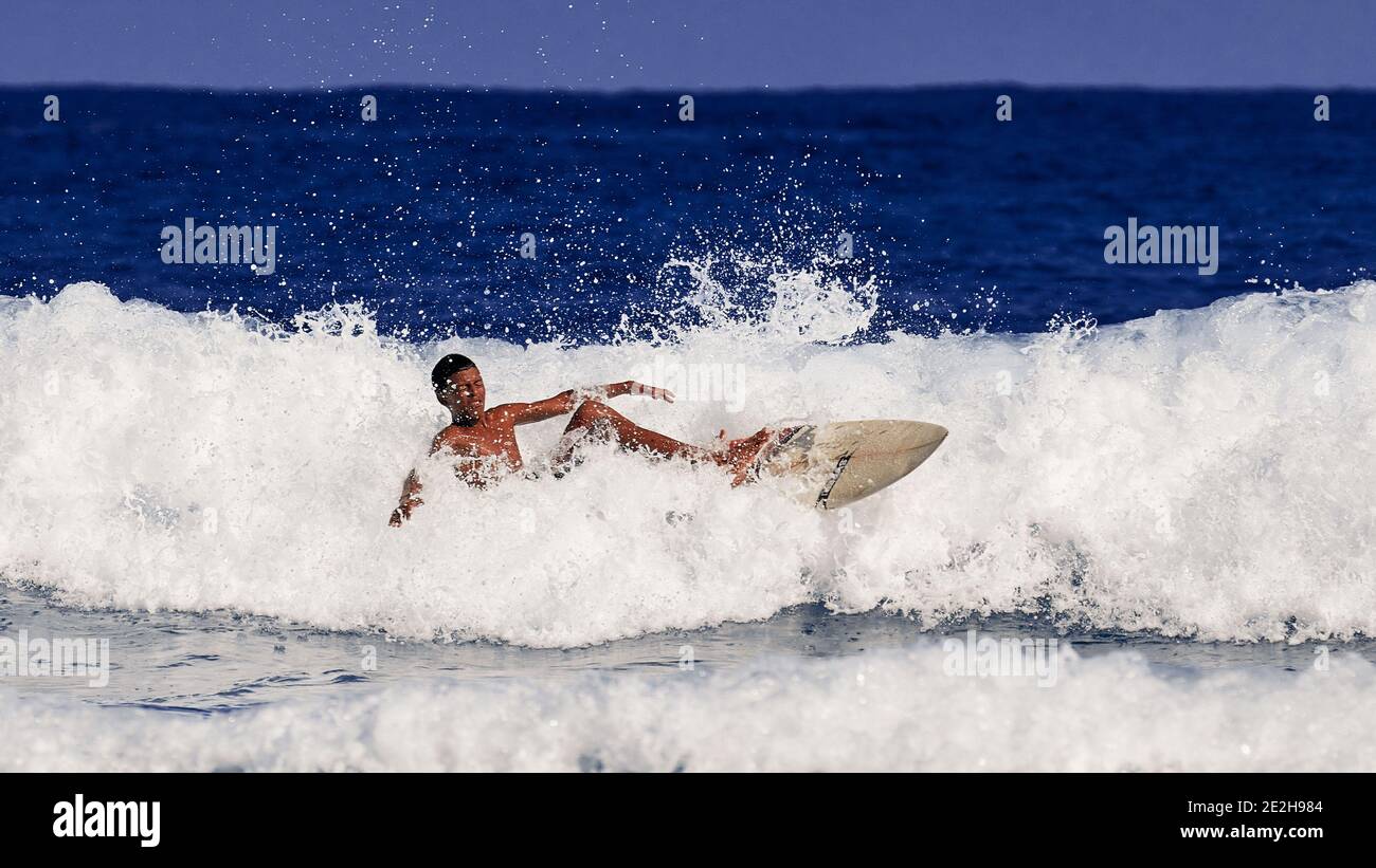 Surfer school. A young guy learning to stand on a surfboard. Surfer on ...