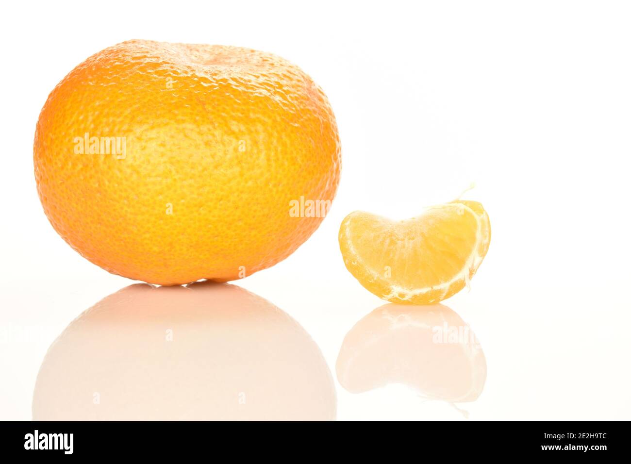 One whole mandarin and one whole slice of peeled bright yellow, juicy ...