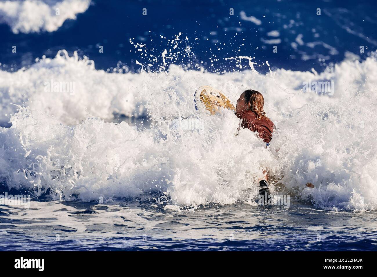 Surfer school. A young guy learning to stand on a surfboard. Surfer on ...