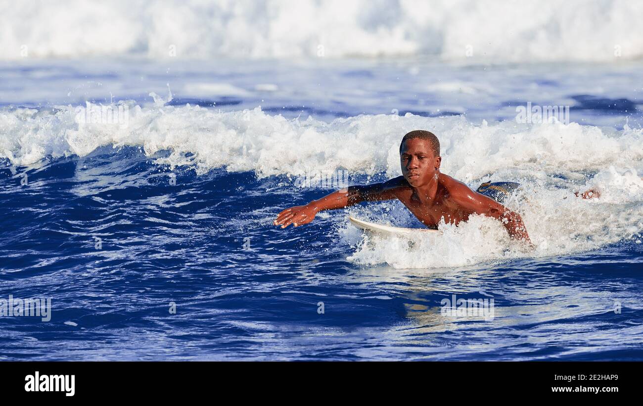 Surfer school. A young guy learning to stand on a surfboard. Surfer on ...