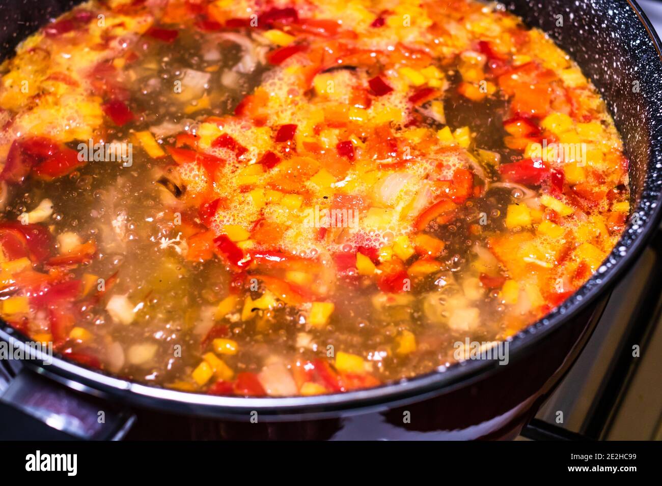 Preparation of soup with chicken and vegetables. Close up of boiling ...