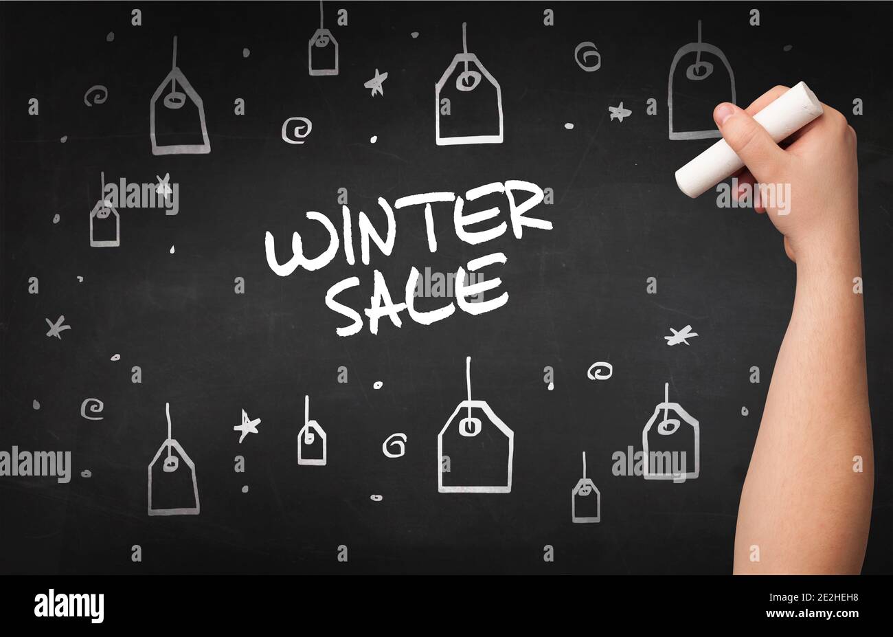 Hand drawing WINTER SALE inscription with white chalk on blackboard ...