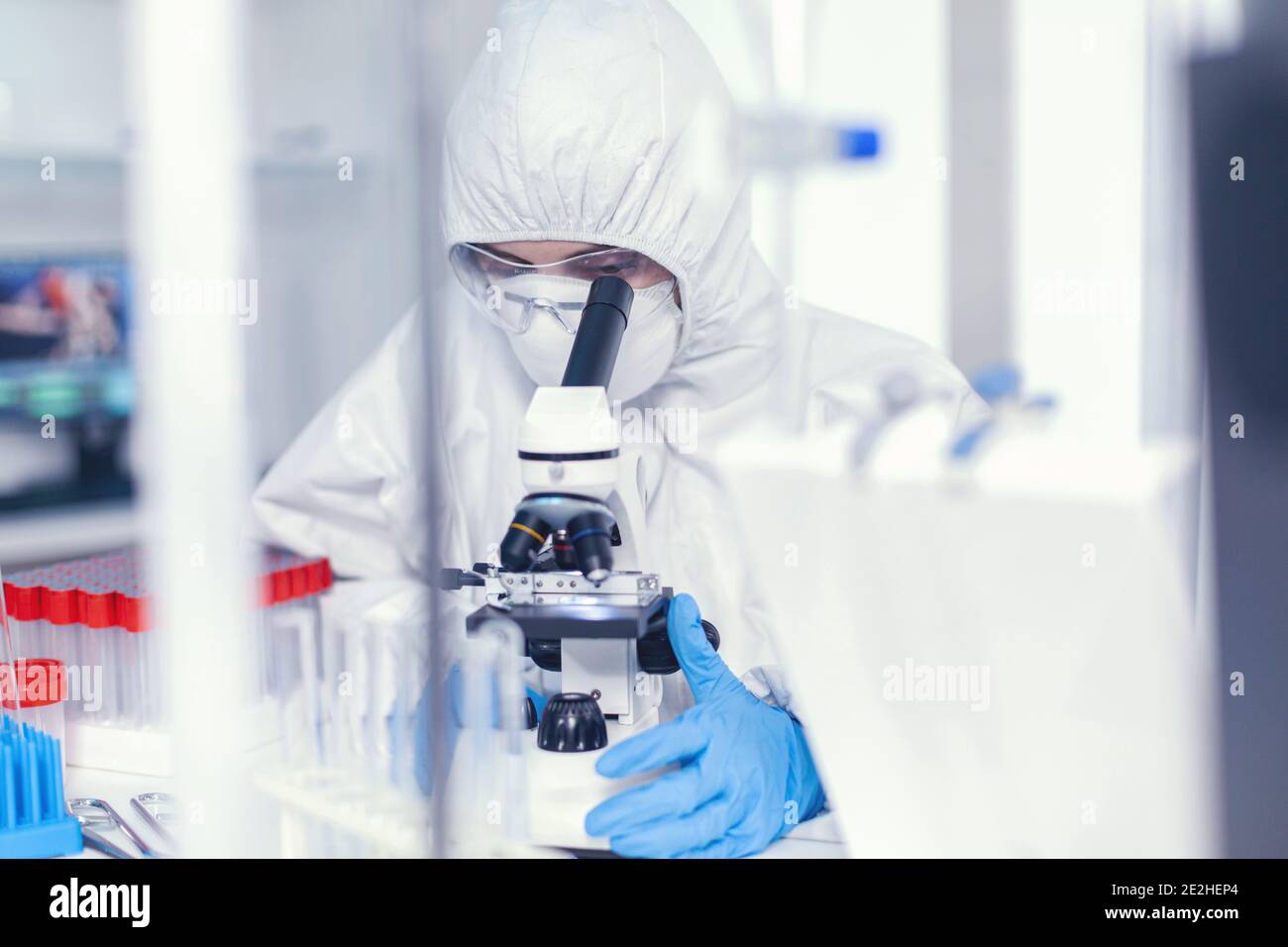 Scientist in sterile protection suit analysing coronavirus looking ...
