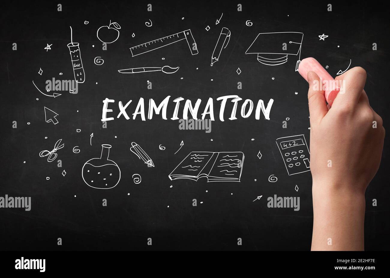 Hand drawing EXAMINATION inscription with white chalk on blackboard ...