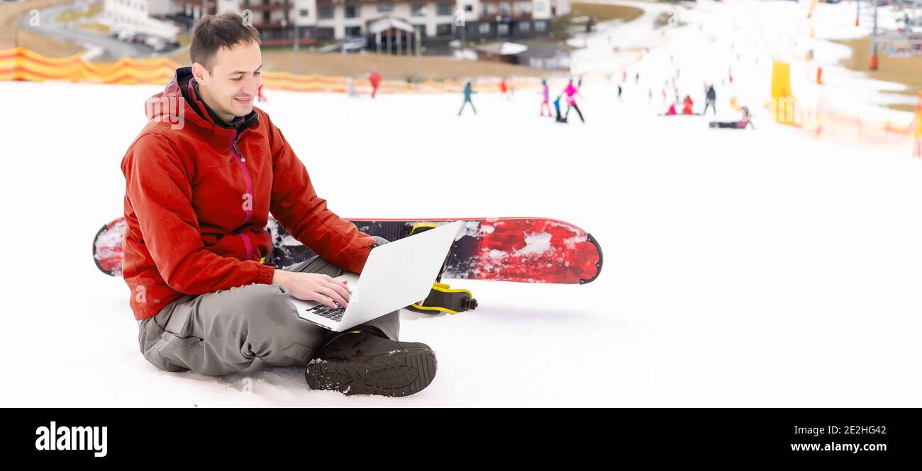 male snowboarder using laptop on snowy mountain landscape Stock Photo ...