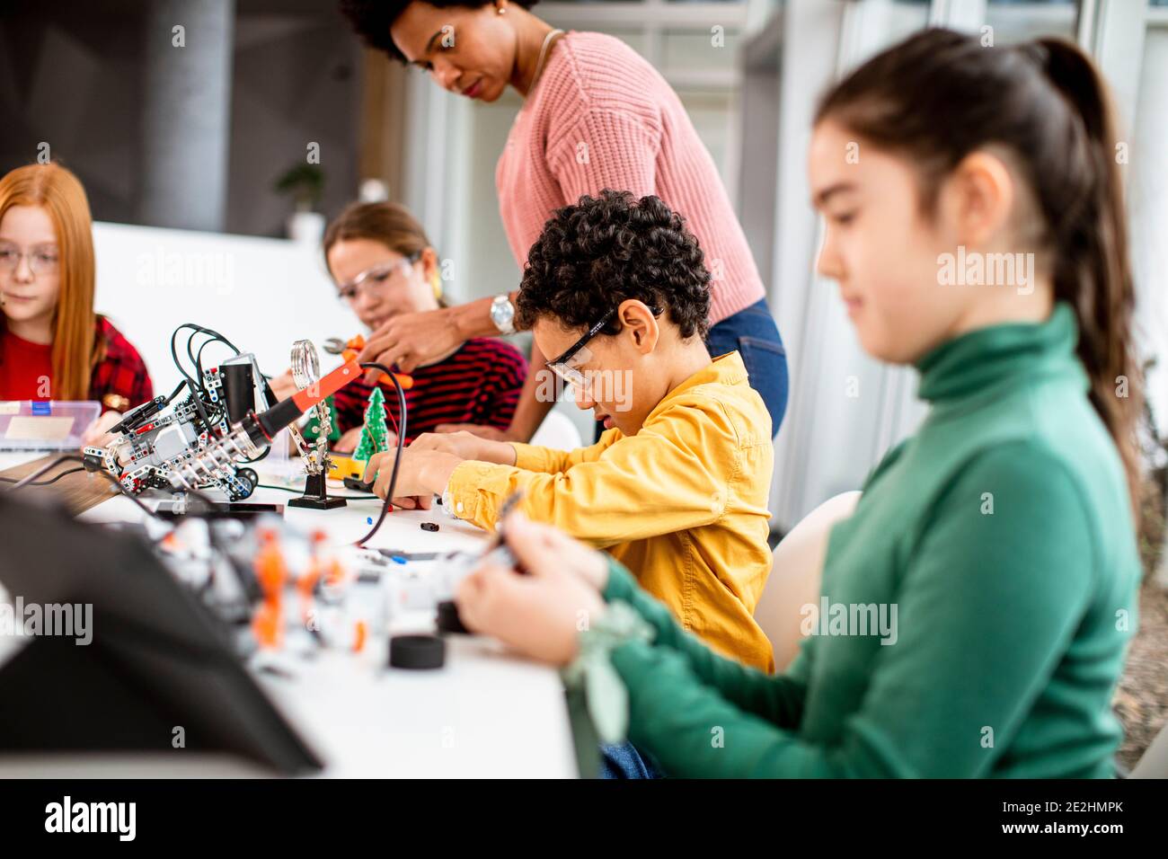 Smily African American female science teacher with group of kids ...