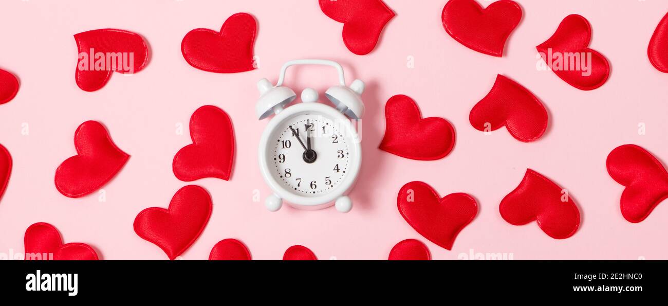 Time for love. Alarm clock and red hearts on pink background. Valentine ...